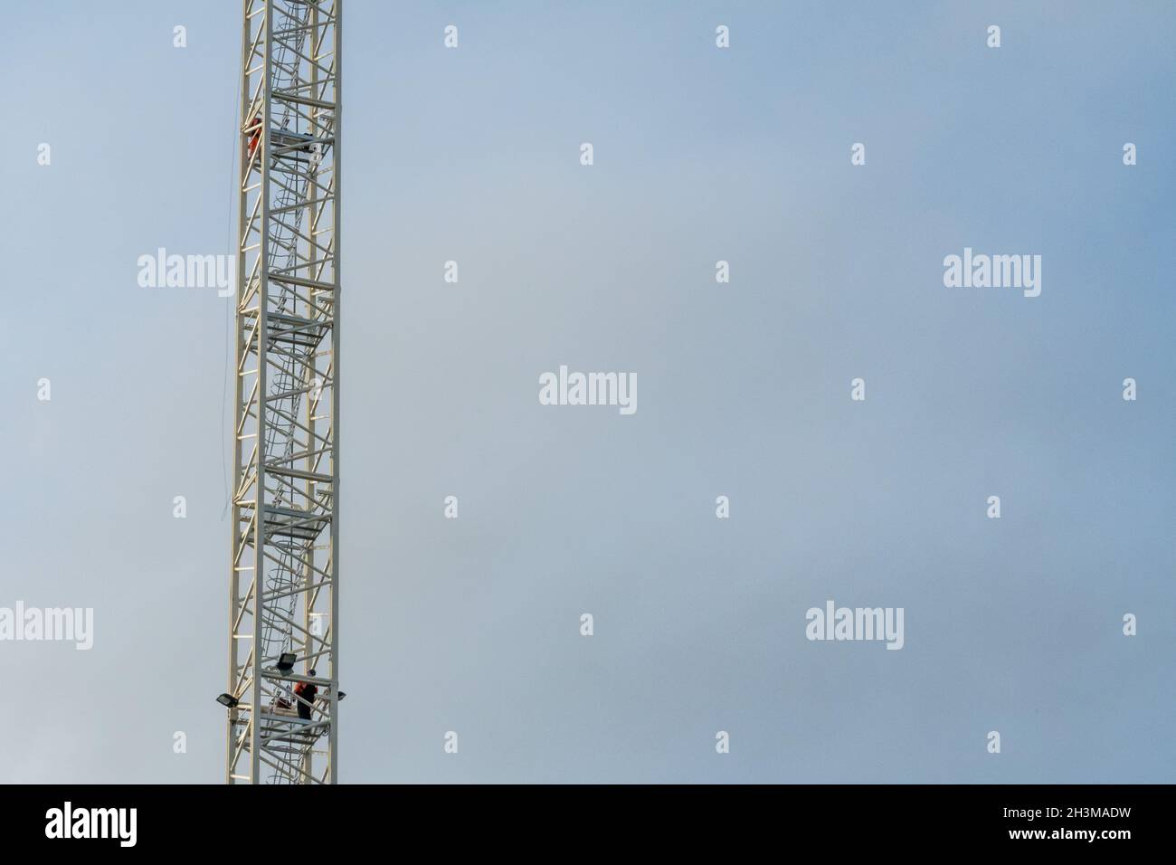 A construction worker descends the ladders of a tower crane Stock Photo ...