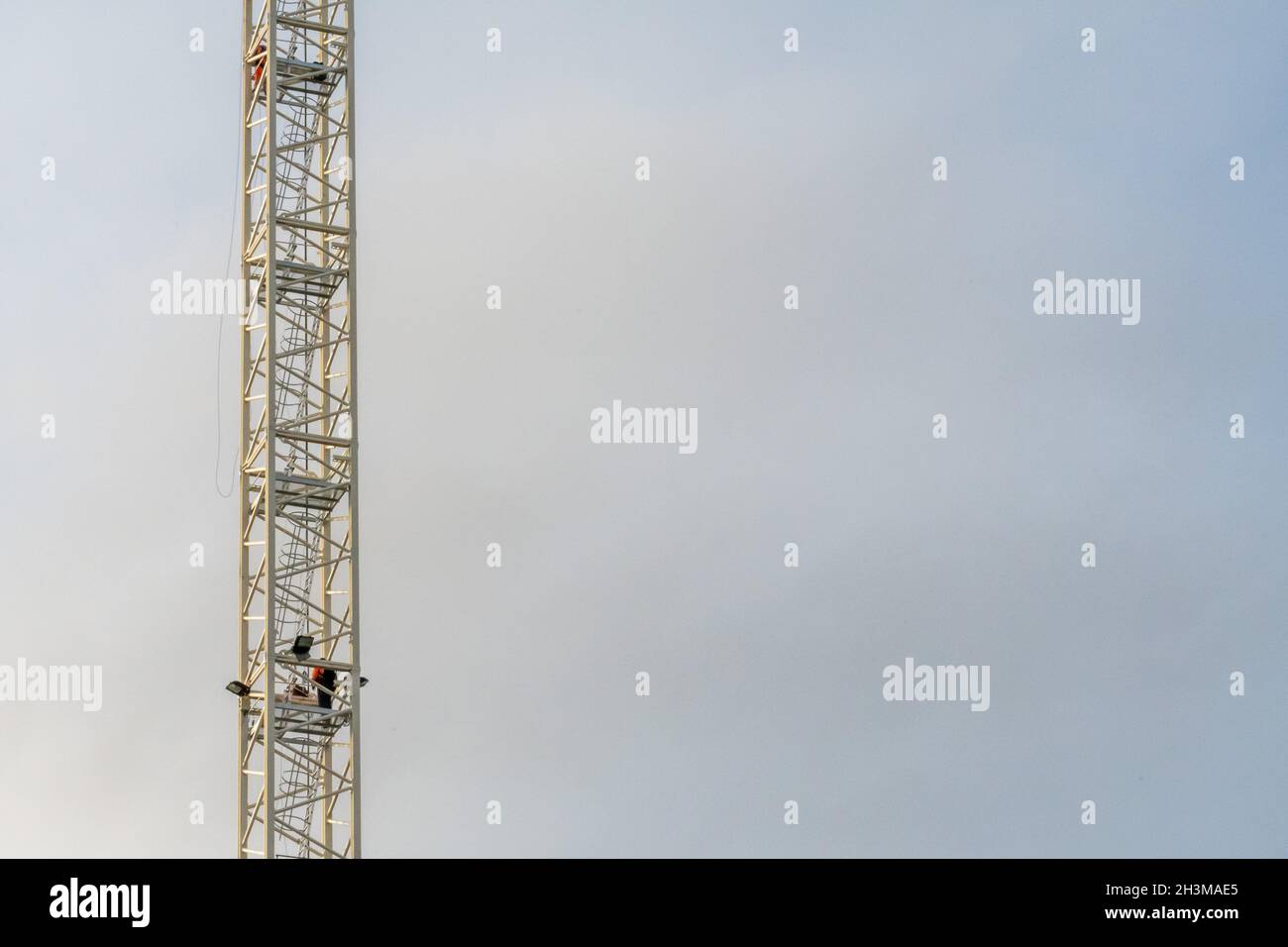 A construction worker descends the ladders of a tower crane Stock Photo ...