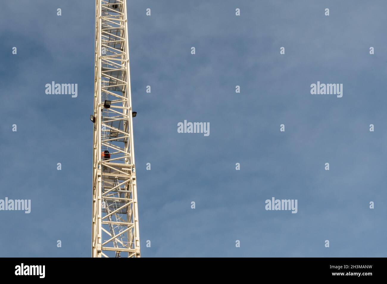 A construction worker descends the ladders of a tower crane Stock Photo ...