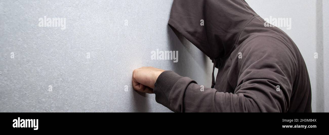 banner of angry man in a gray hood slams his fist against the white ...