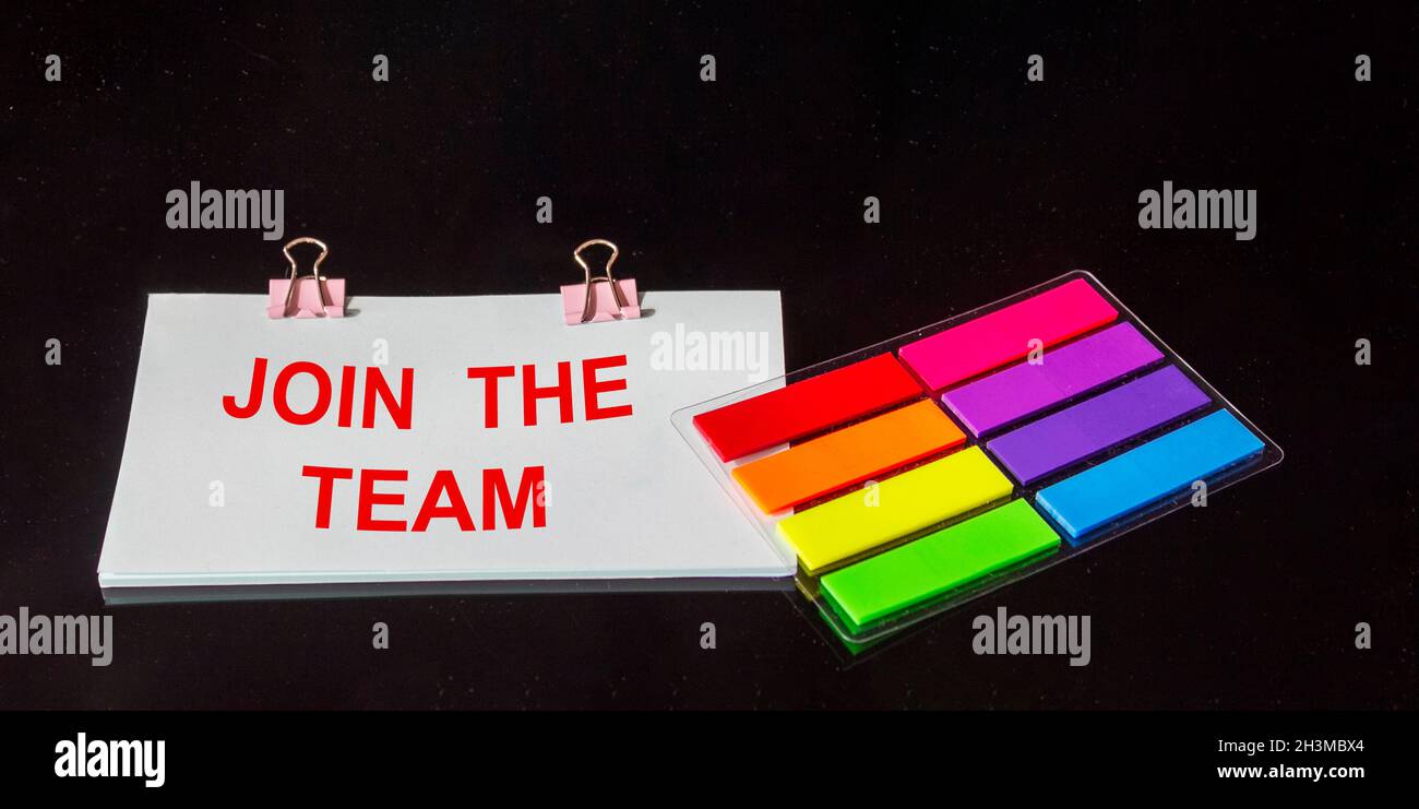 Text Join the team, written in a notebook, next to stickers, on a black ...
