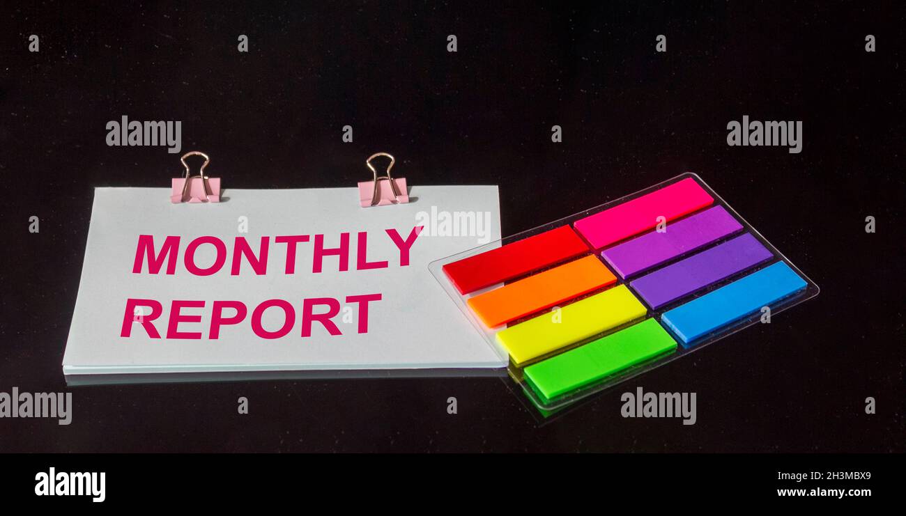 Monthly report written on a sticky note and black background Stock ...