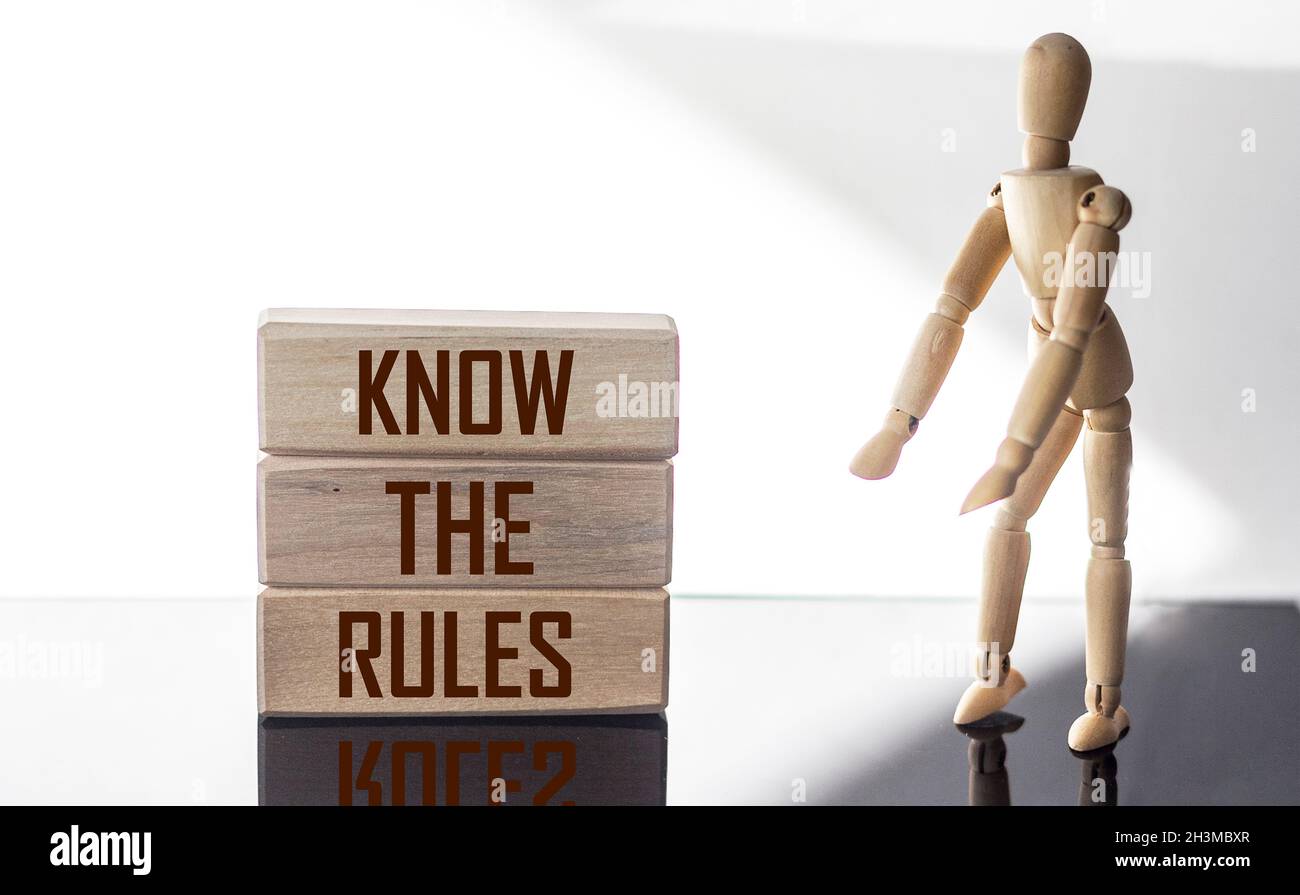 Know the rules text on wooden blocks with a wooden doll on a light ...