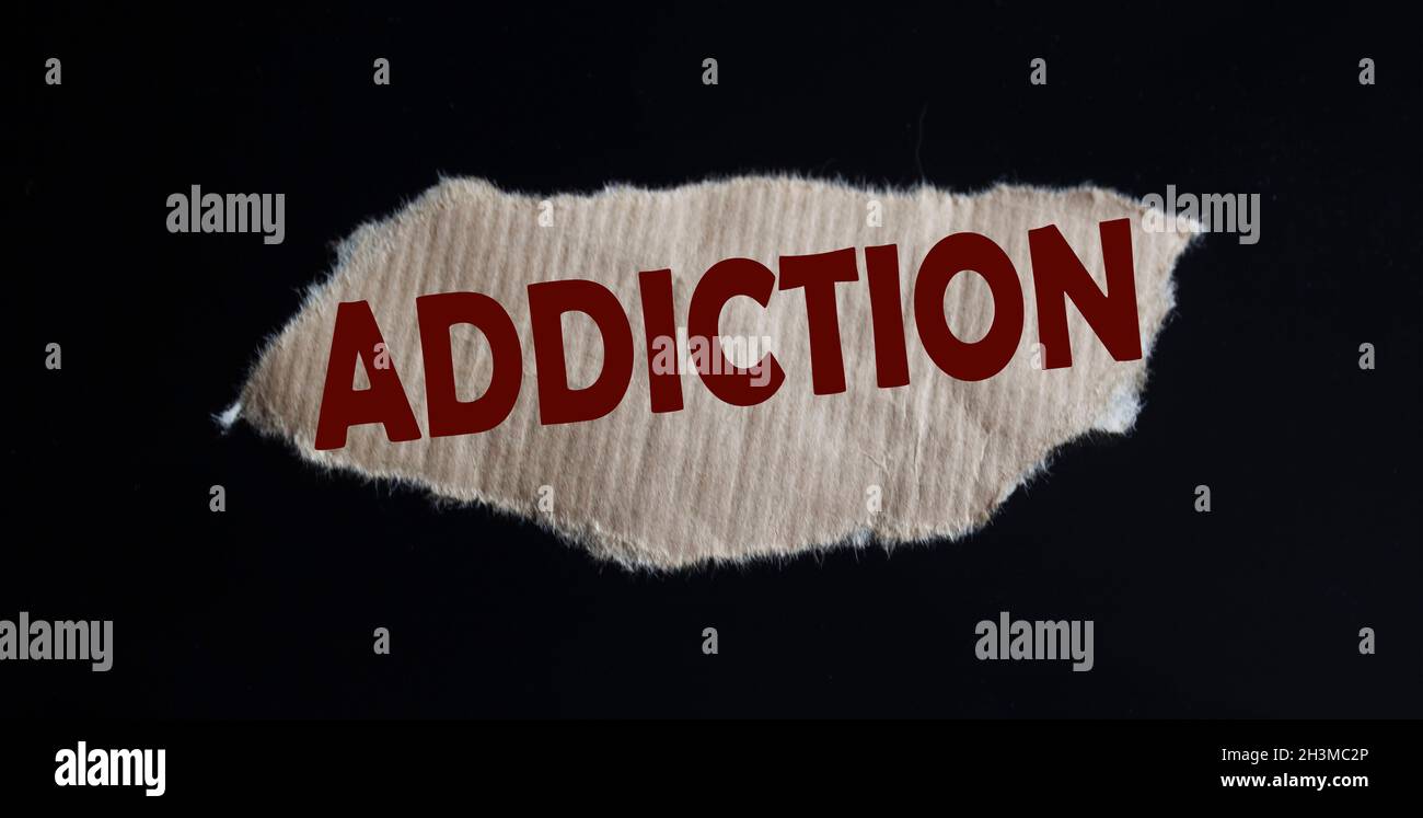 The word addiction is written on brown cardboard and black background ...