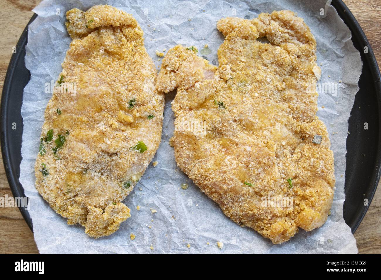 homemade breaded chicken cutlet in a crisp plate to be cooked in the ...