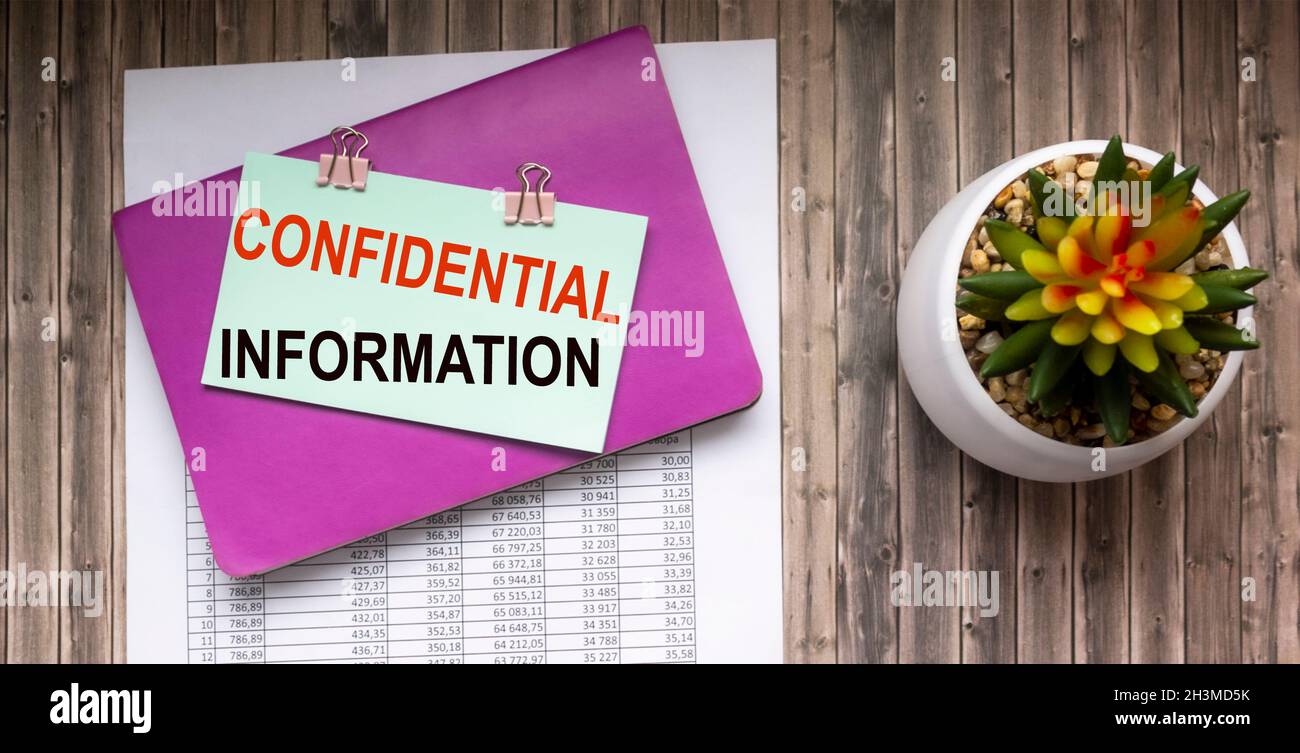 Confidential information text written on the table with documents Stock ...