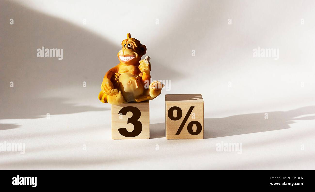3 percent on wooden blocks and a white background, figurine of a monkey ...