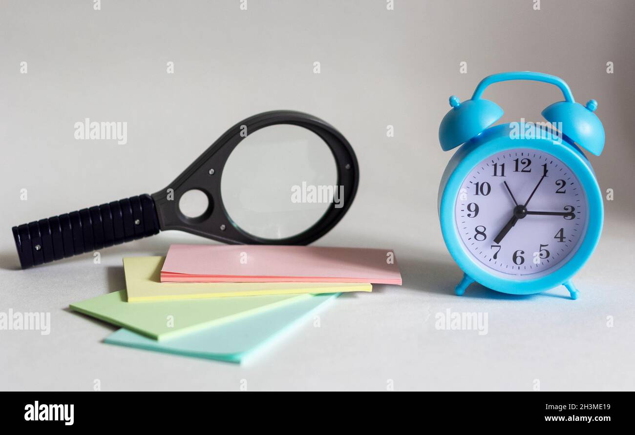 Colored stickers, magnifier and alarm clock. White background Stock ...