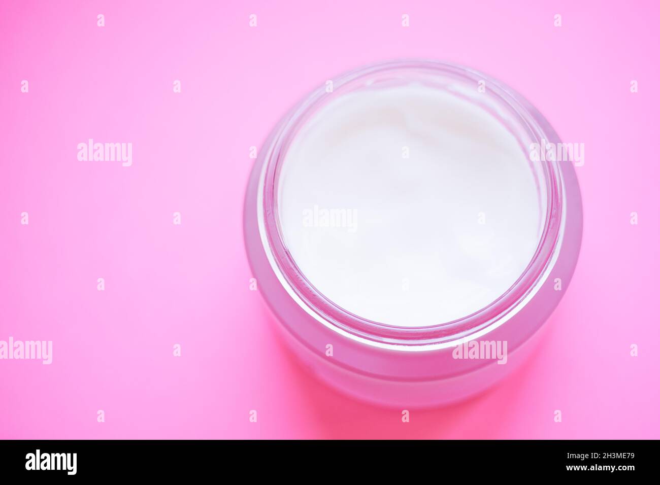 Open jar of cream on a pink table Stock Photo - Alamy