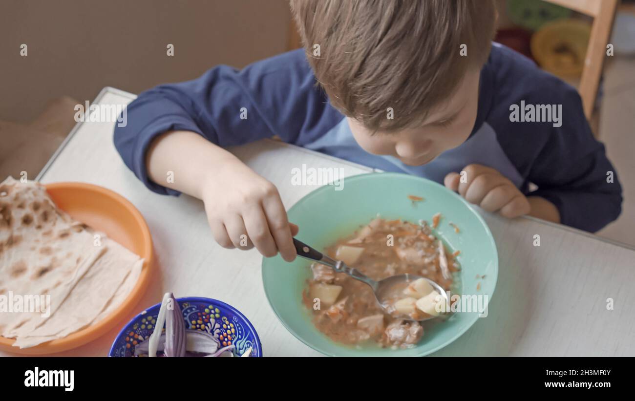 Young boy eating soup hi-res stock photography and images - Alamy