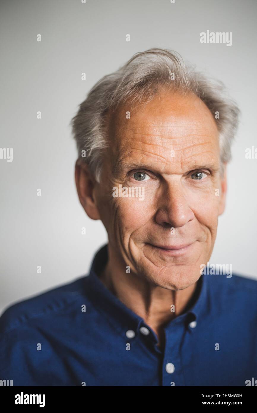 Smiling male owner against wall Stock Photo - Alamy