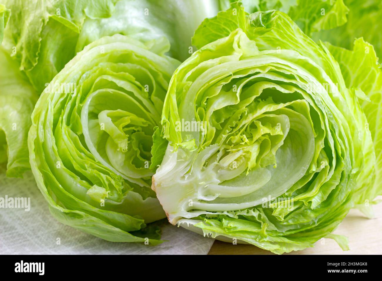 Fresh green iceberg lettuce salad leaves cut on light background on the ...