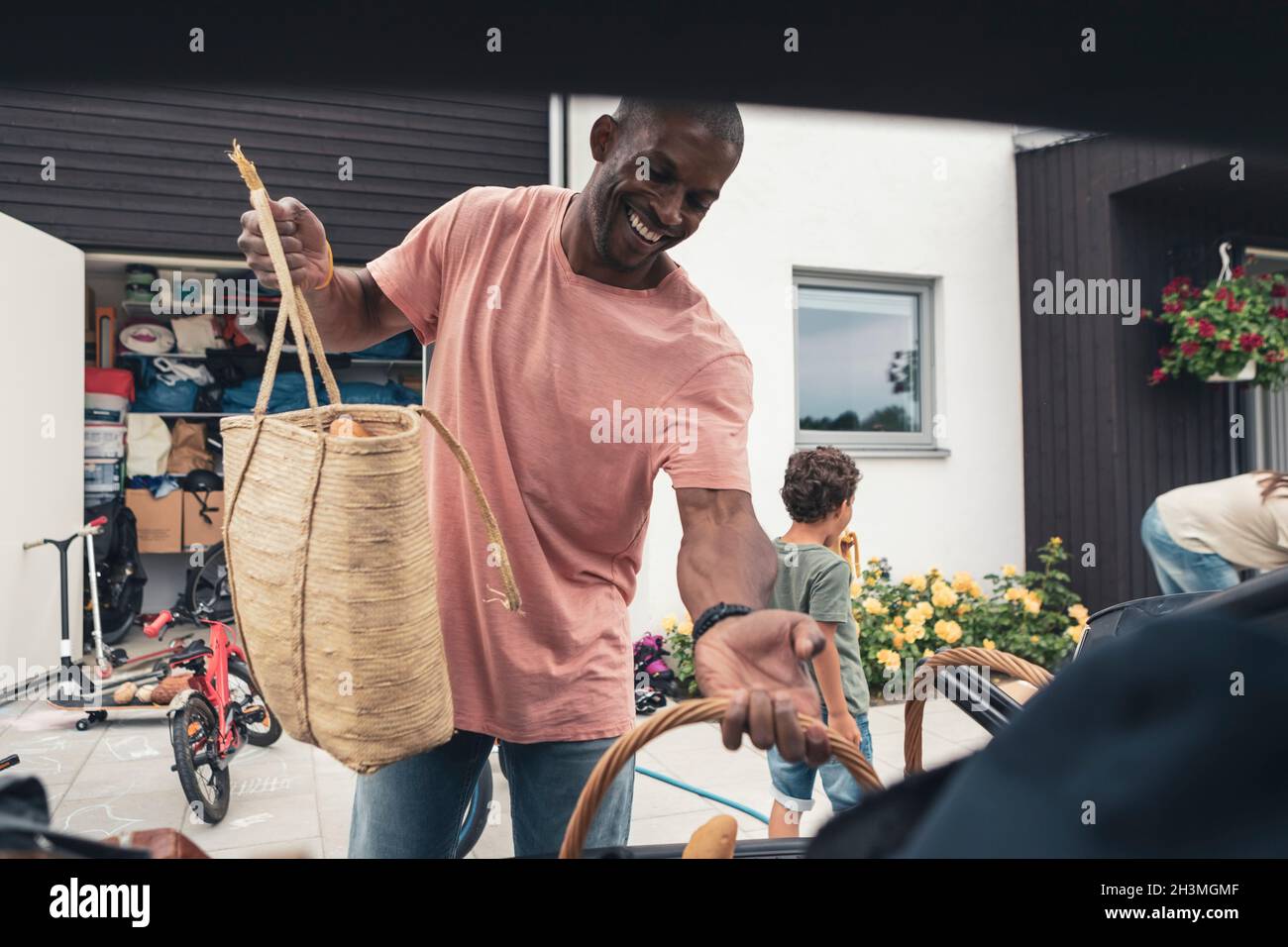 Happy man loading luggage in car trunk Stock Photo - Alamy