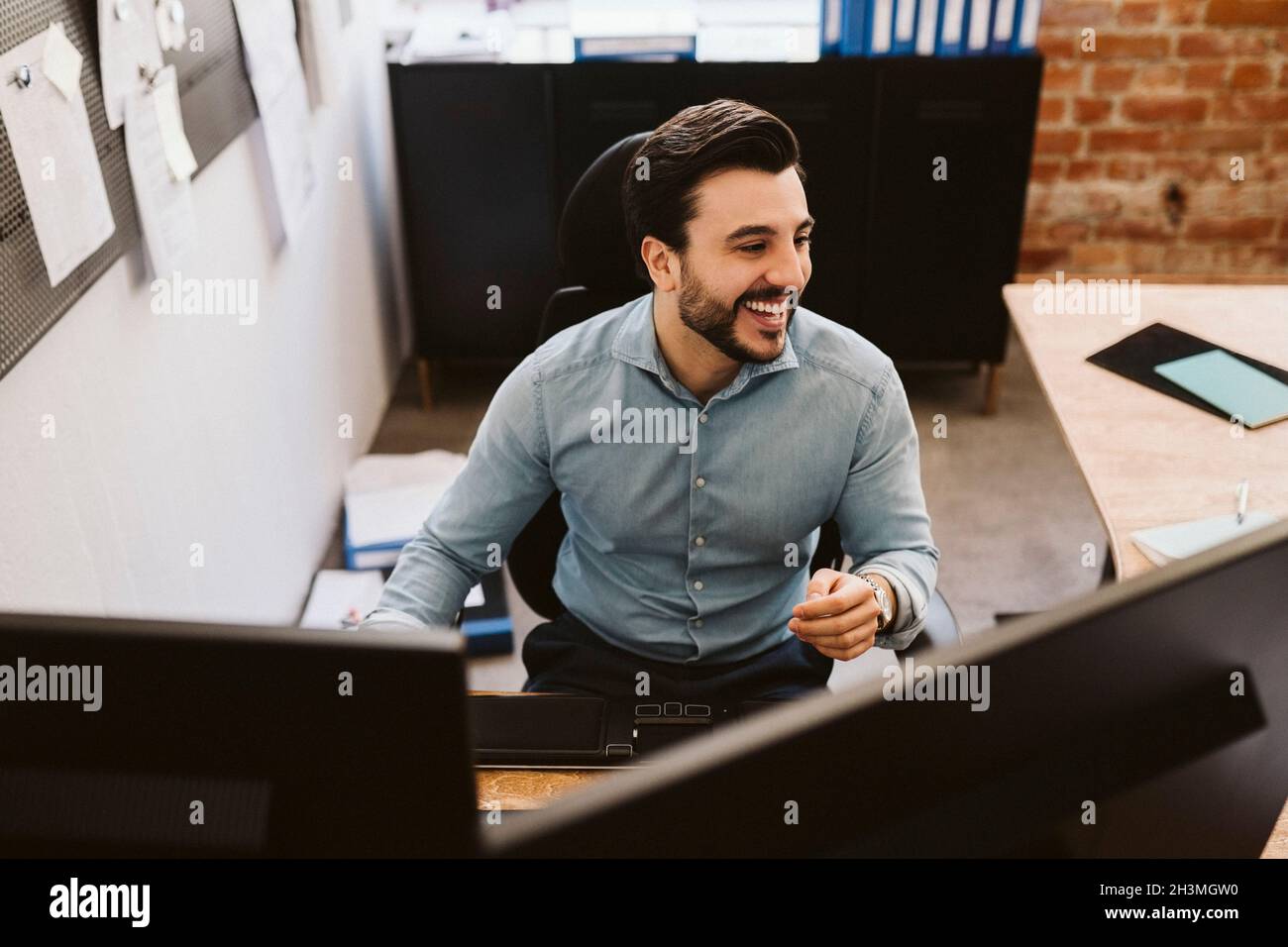 Cheerful man sitting office desk hi-res stock photography and images ...