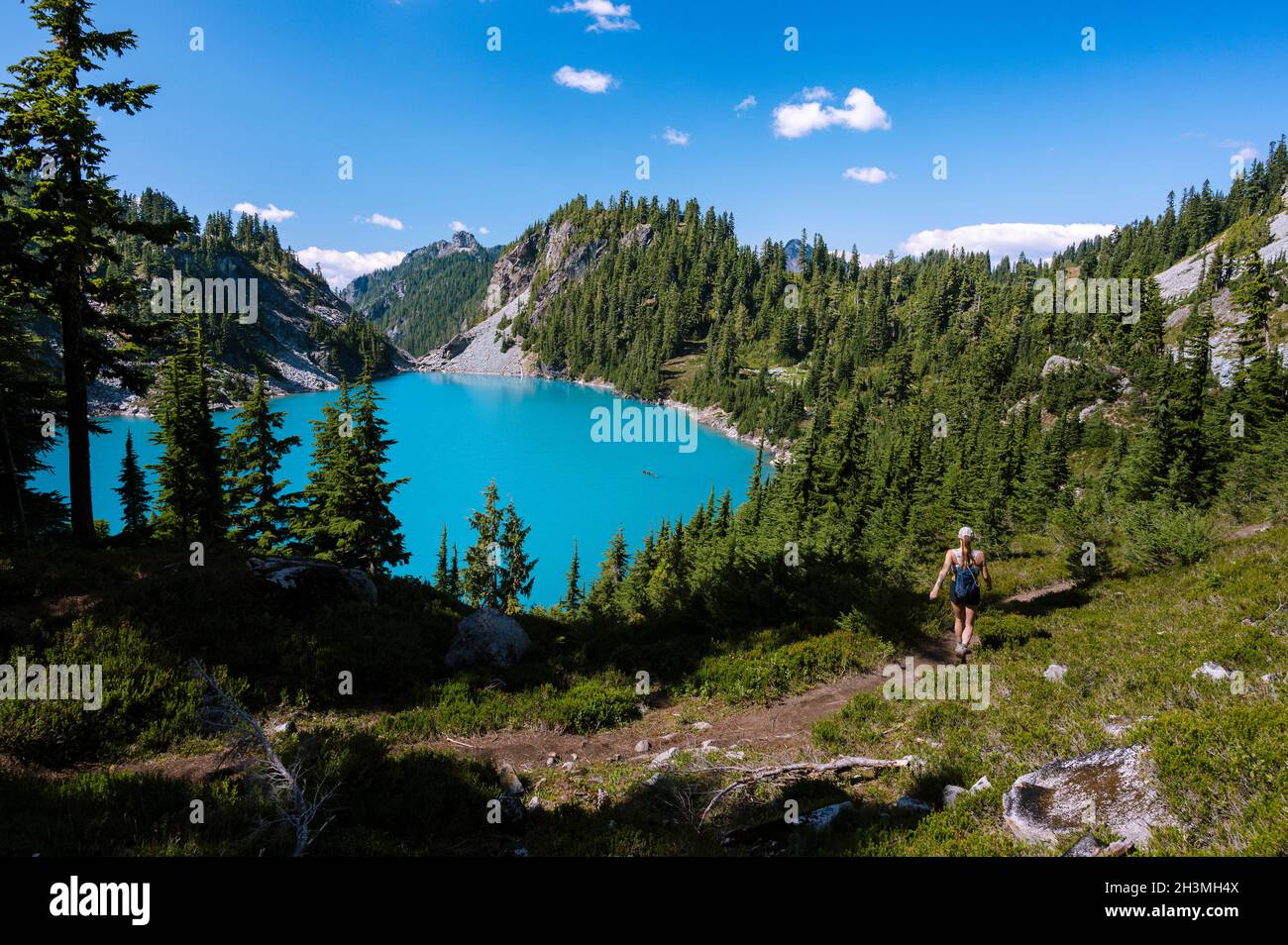 Female Hiking Past Beautiful Turquoise Alpine Lake Stock Photo - Alamy