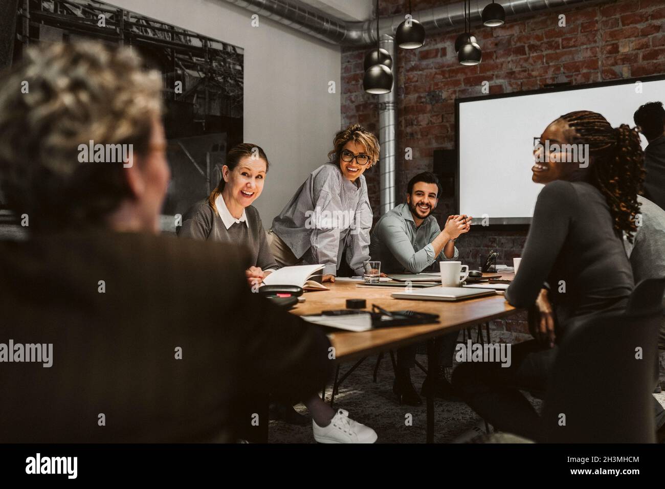 Group professionals sitting table smiling hi-res stock photography and ...