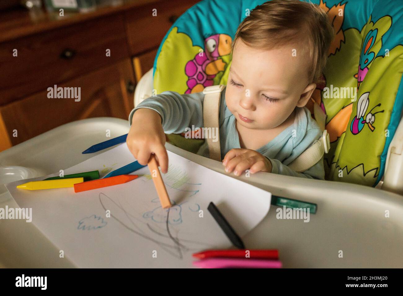 Small boy sitting in high chair and learning how to draw with cr Stock ...