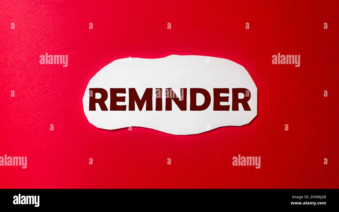 Reminder, text is written on a piece of paper and a red background. Do ...