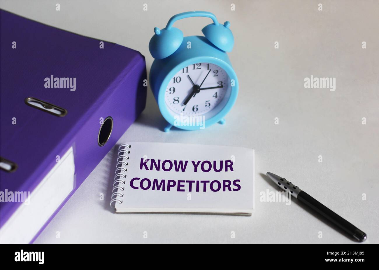 The text Know Your Competitors is written on a notebook and a white ...