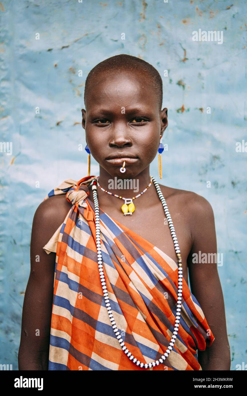 TOPOSA TRIBE, SOUTH SUDAN - MARCH 12, 2020: Girl in checkered colorful ...