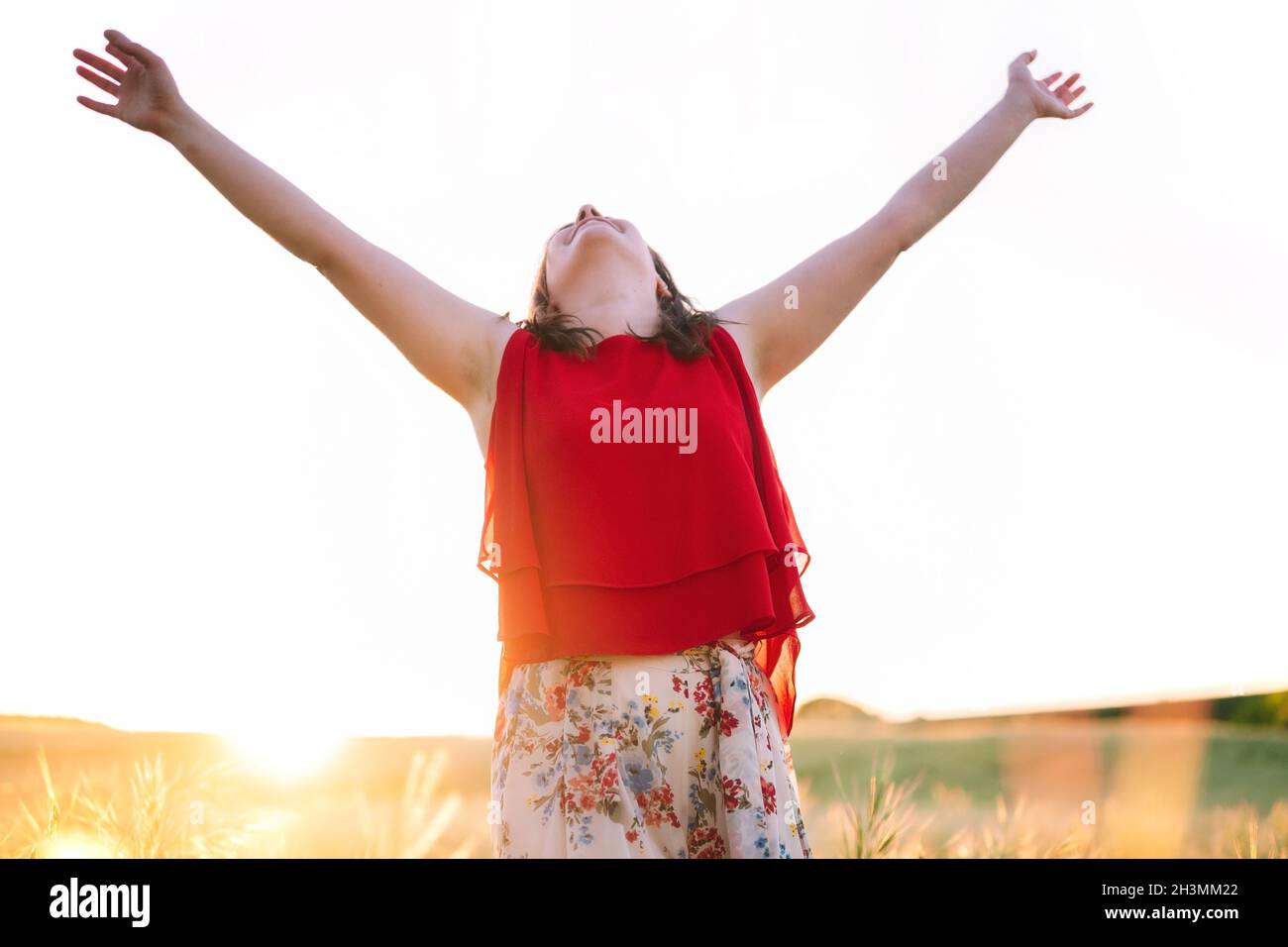 Young woman arms raised up to sky, celebrating freedom. Positive ...