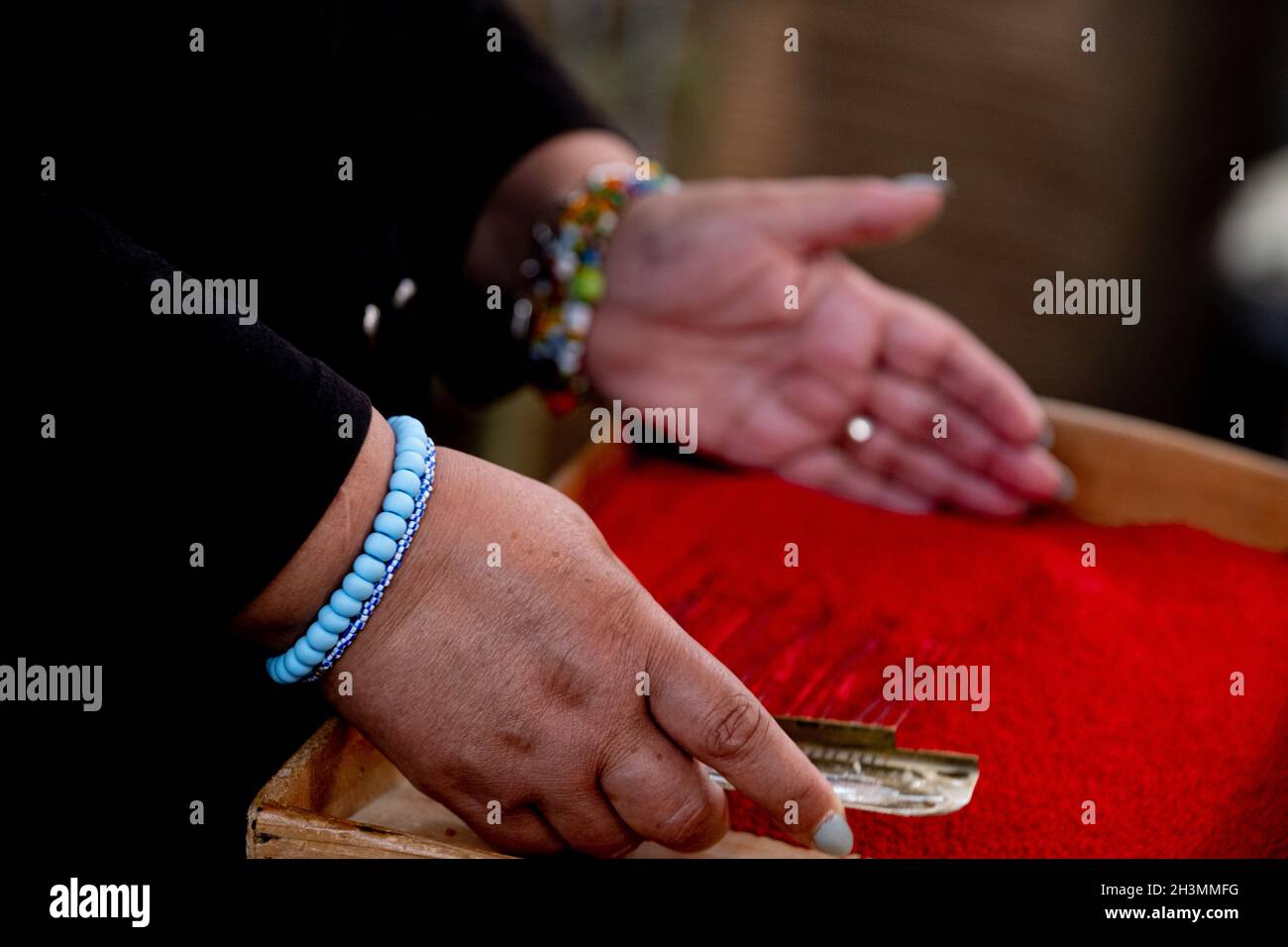 The hands of an impiraressa, the traditional Venetian beads threader ...