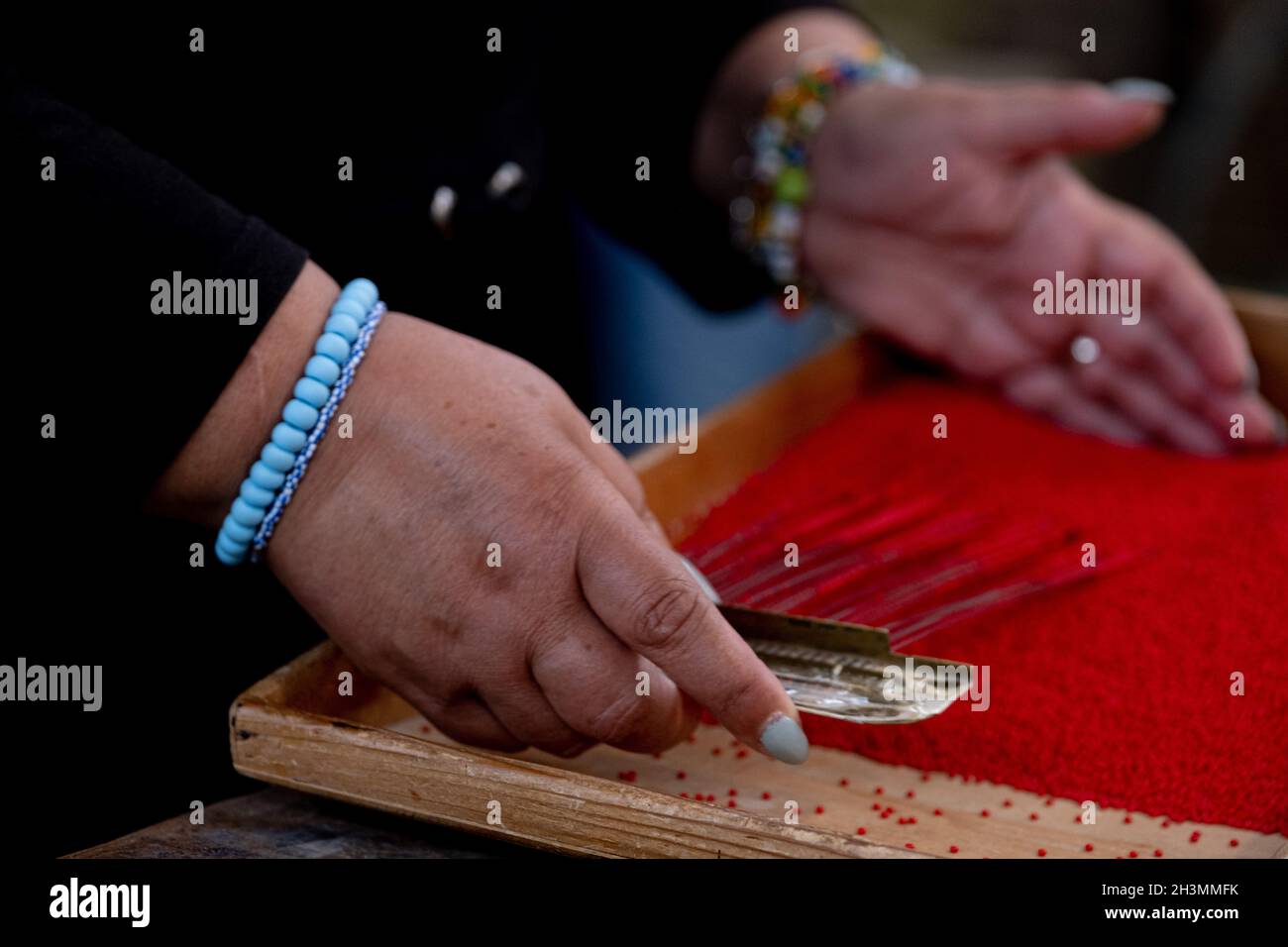 The hands of an impiraressa, the traditional Venetian beads threader ...