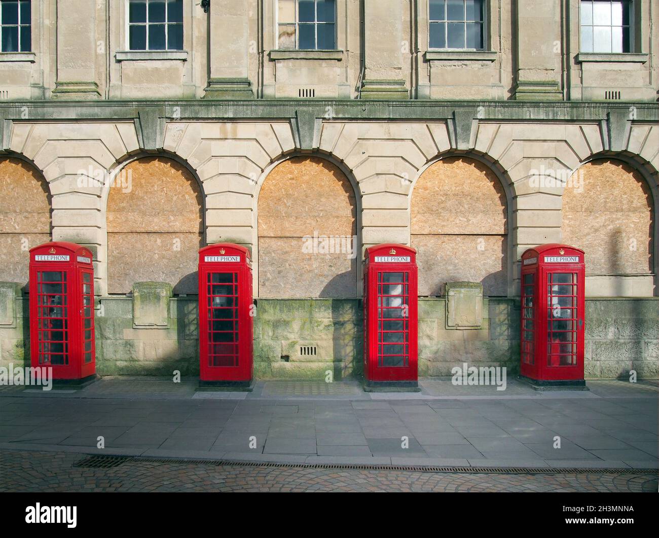 A line of four traditional british red phone boxes outside an old ... A line of four traditional british red phone boxes outside an old ...