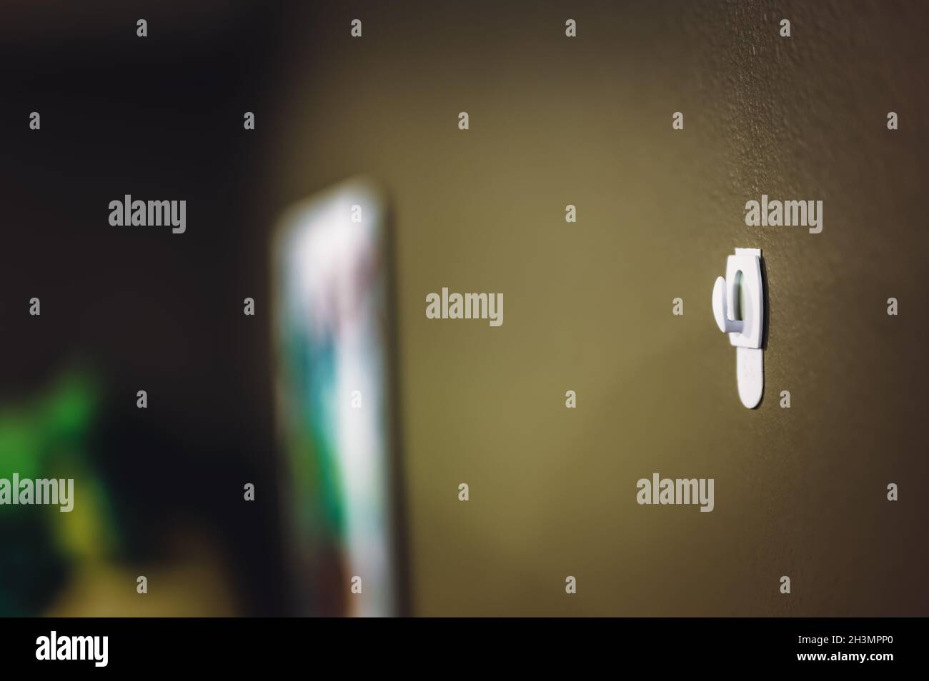 Selective focus on adhesive strip wall hanger that can be removed by ...