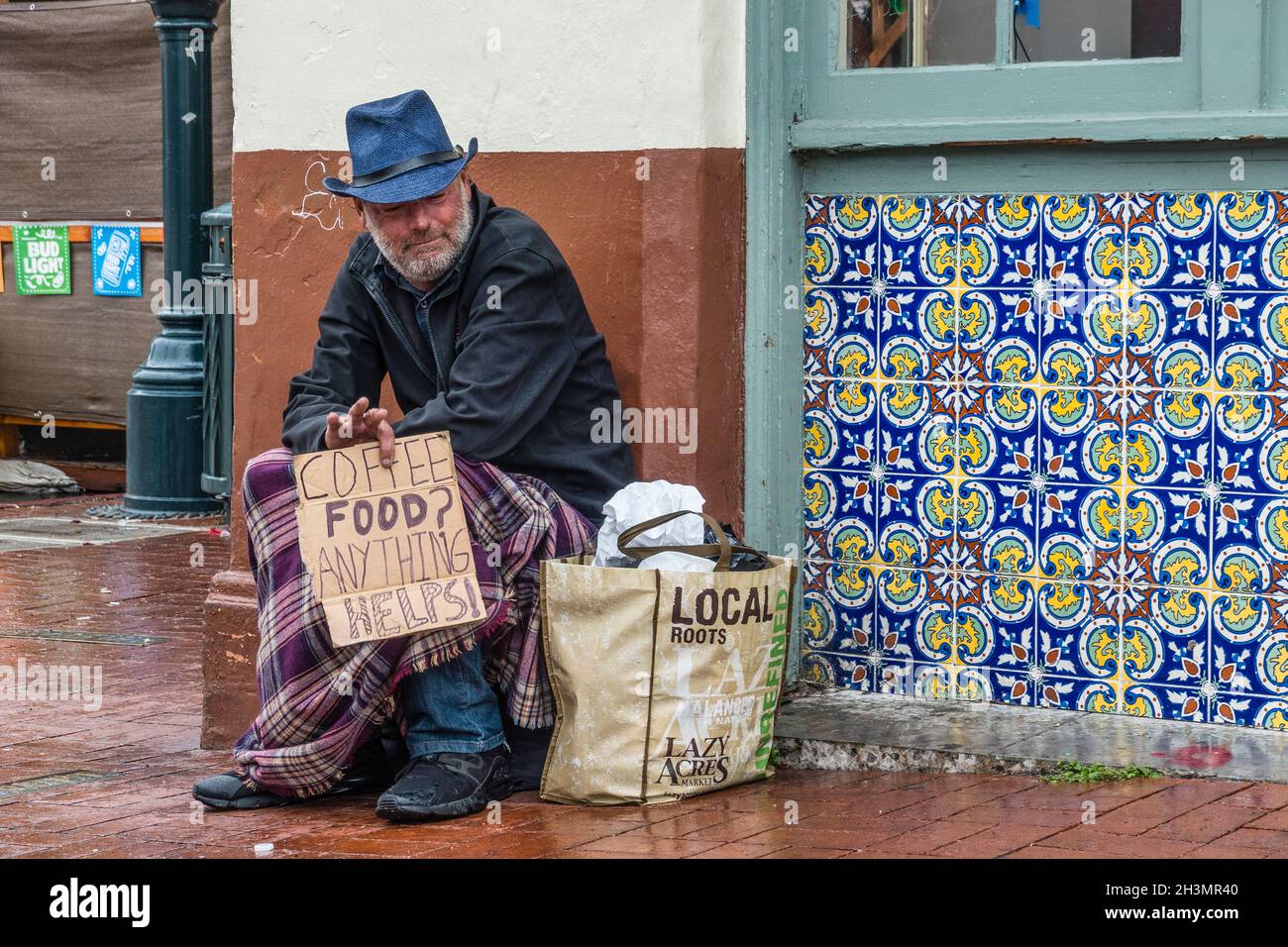 A middle-aged male begs holding his cardboard sign up in front of a ...