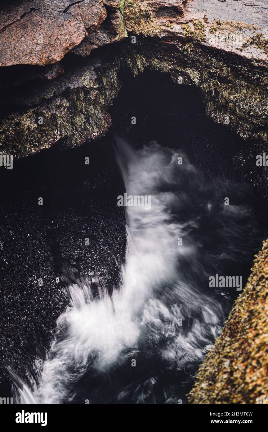 Rising tide waves crashing into a natural rock inlet called Thunder ...