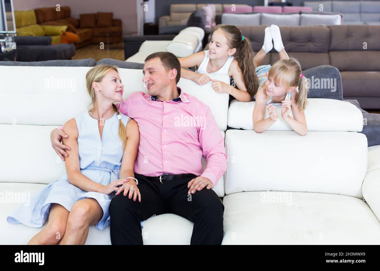 Parents with kids is pleased by new sofa Stock Photo - Alamy