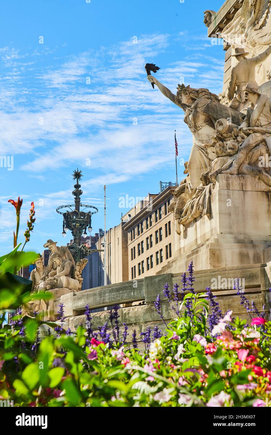 Close view of statues on Soldiers and Sailors Monument next to flowers ...