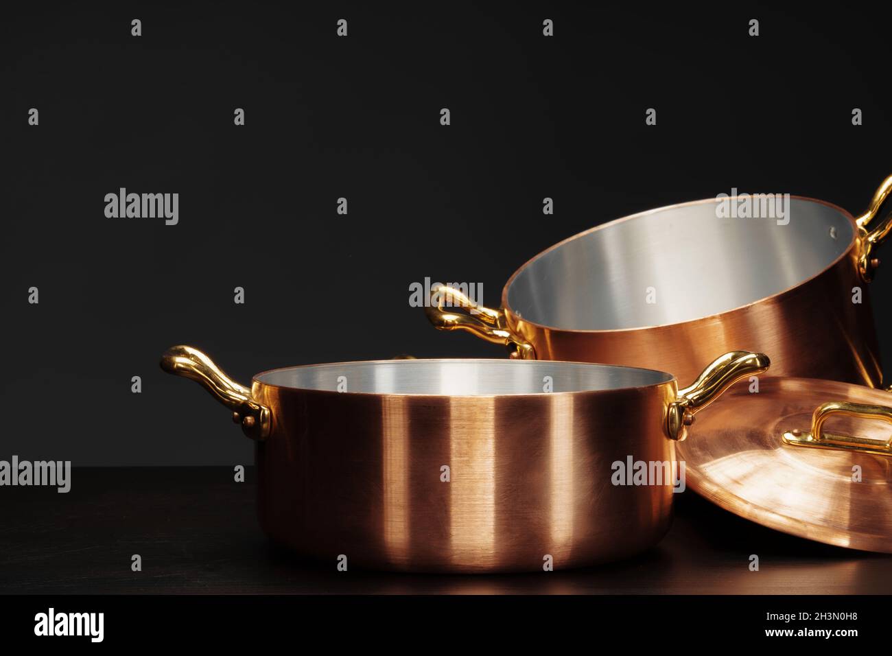 Set of copper cookware over dark background Stock Photo - Alamy