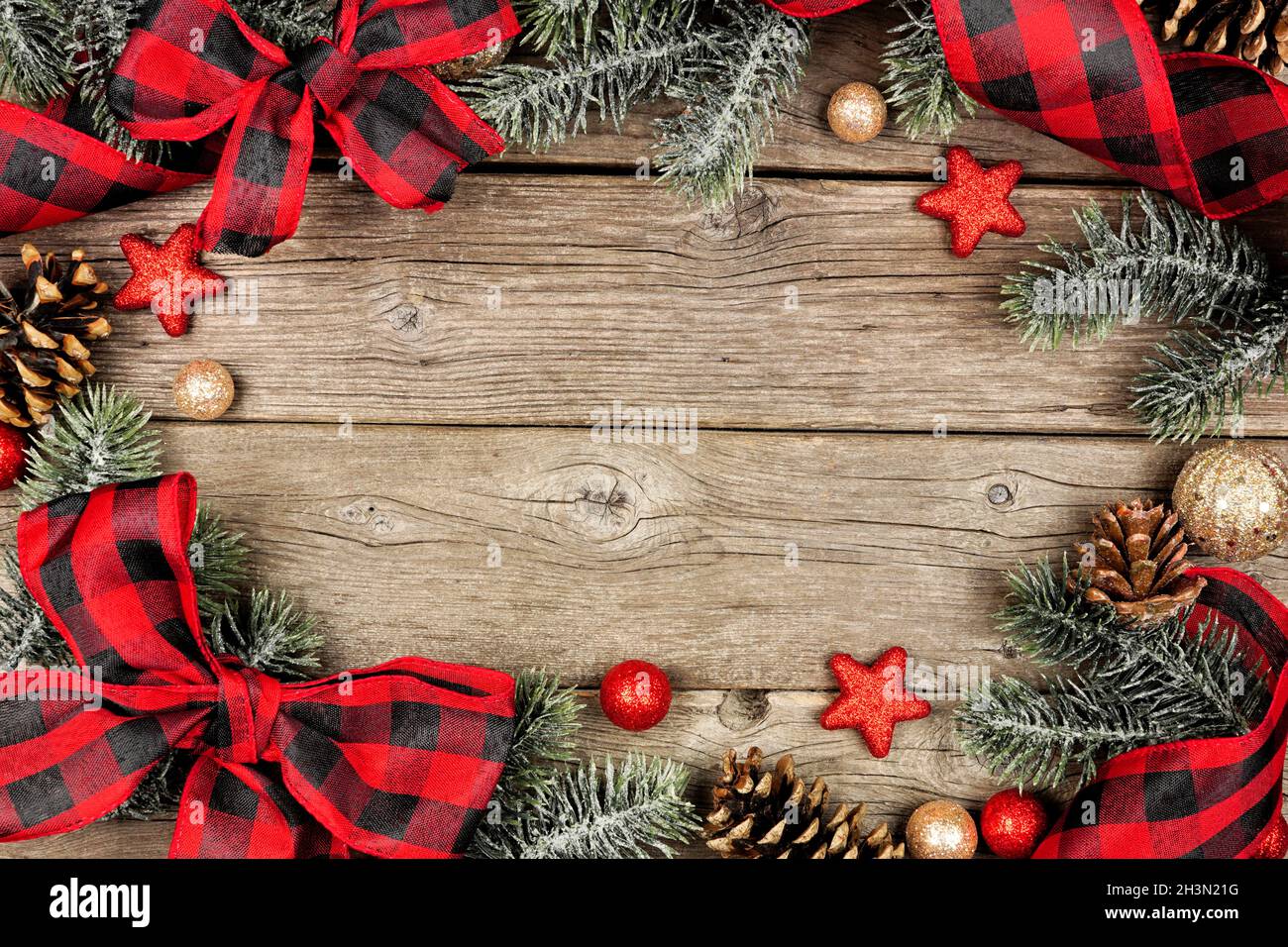 Christmas frame of ornaments, branches and buffalo plaid check ribbon ...