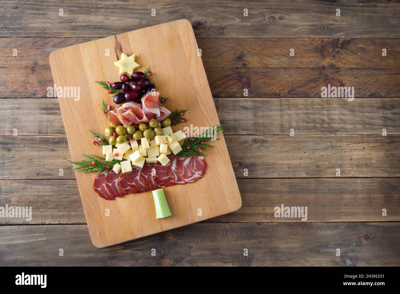 Christmas tree-shaped cheese and charcuterie appetizer board with ...