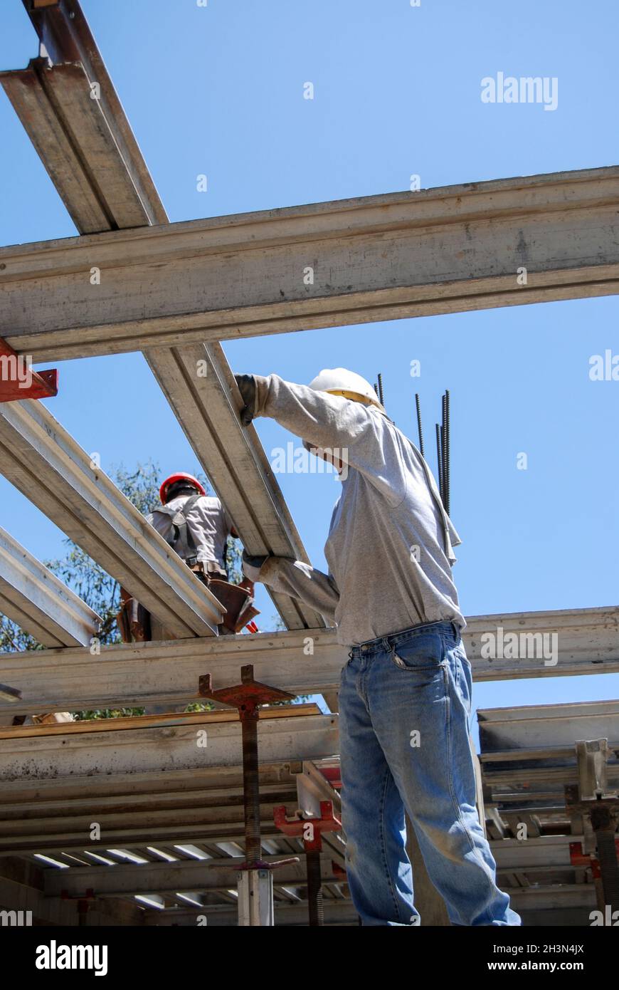 Construction worker installs temporary structural I-beams Stock Photo ...