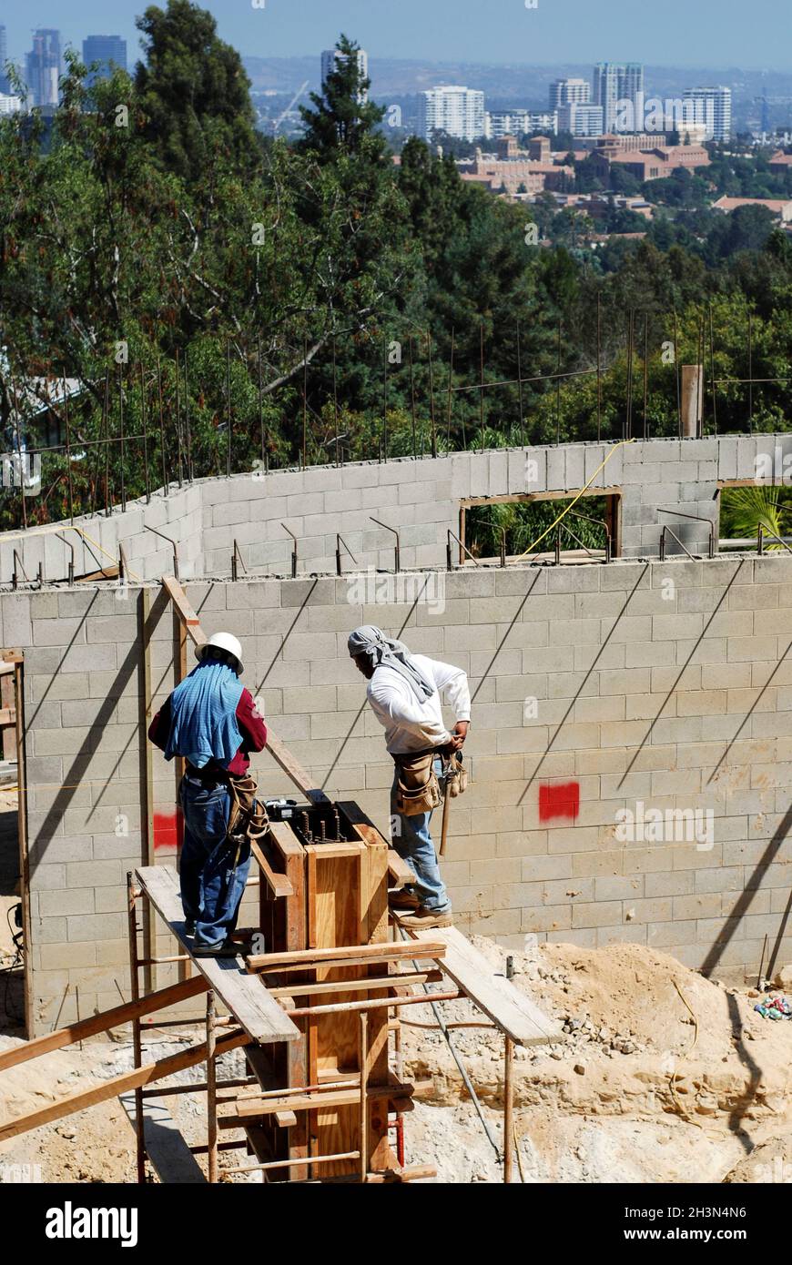 Construction workers building a form for a new concrete support column ...