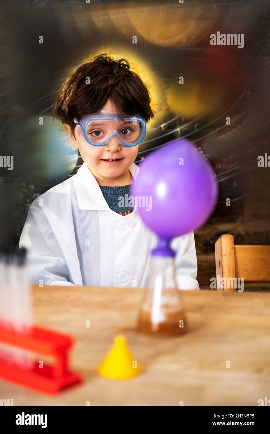 UK, Portrait of smiling boy (4-5) making science experiments at home ...