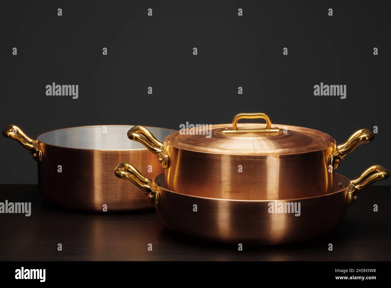 Shiny vintage copper cookware over dark background Stock Photo - Alamy