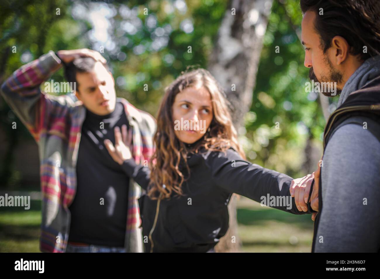 The woman tries to separate the two aggressive, angry, nervous and ...