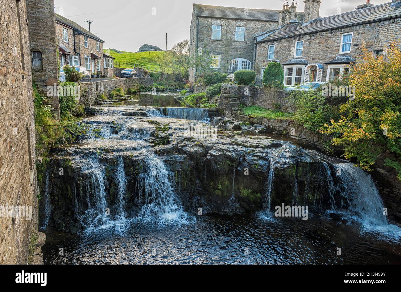The river Ure and waterfall flowing through the market town of Hawes in ...