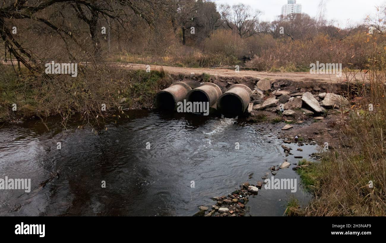 Concrete waste pipes. Streams of water flow through concrete pipes ...