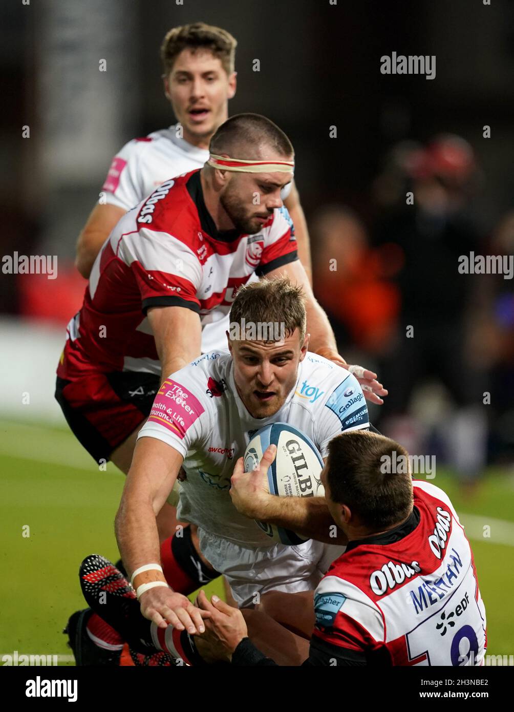 Exeter Chiefs' Ollie Devoto is tackled by Gloucester Rugby's Ben Meehan ...