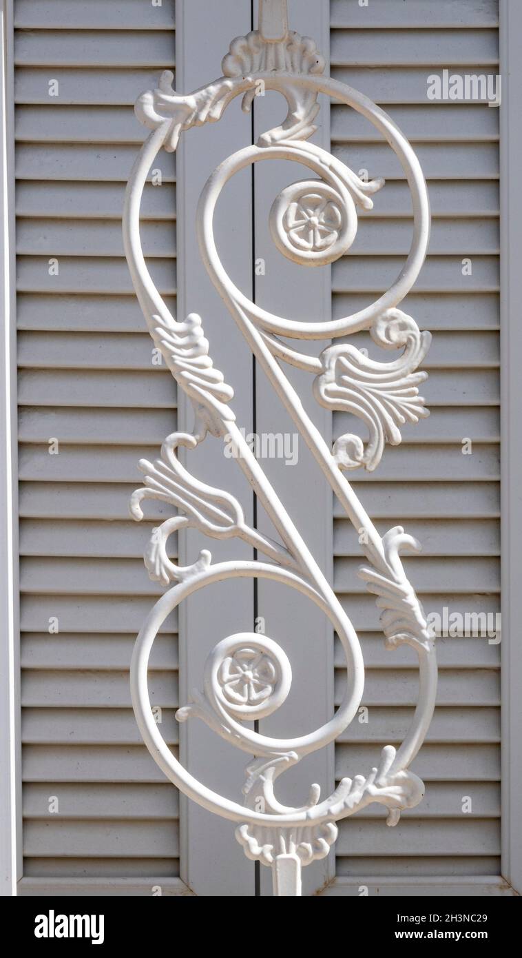 wrought ironwork on a balcony in front of some white painted wooden ...
