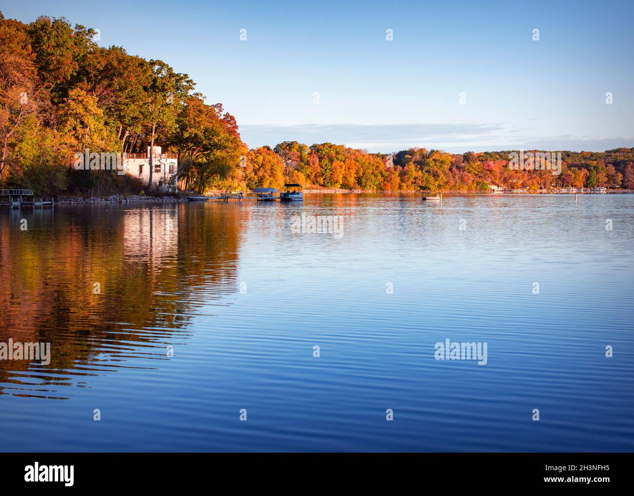 The first morning light hits the shoreline of a lake in Waukesha County ...