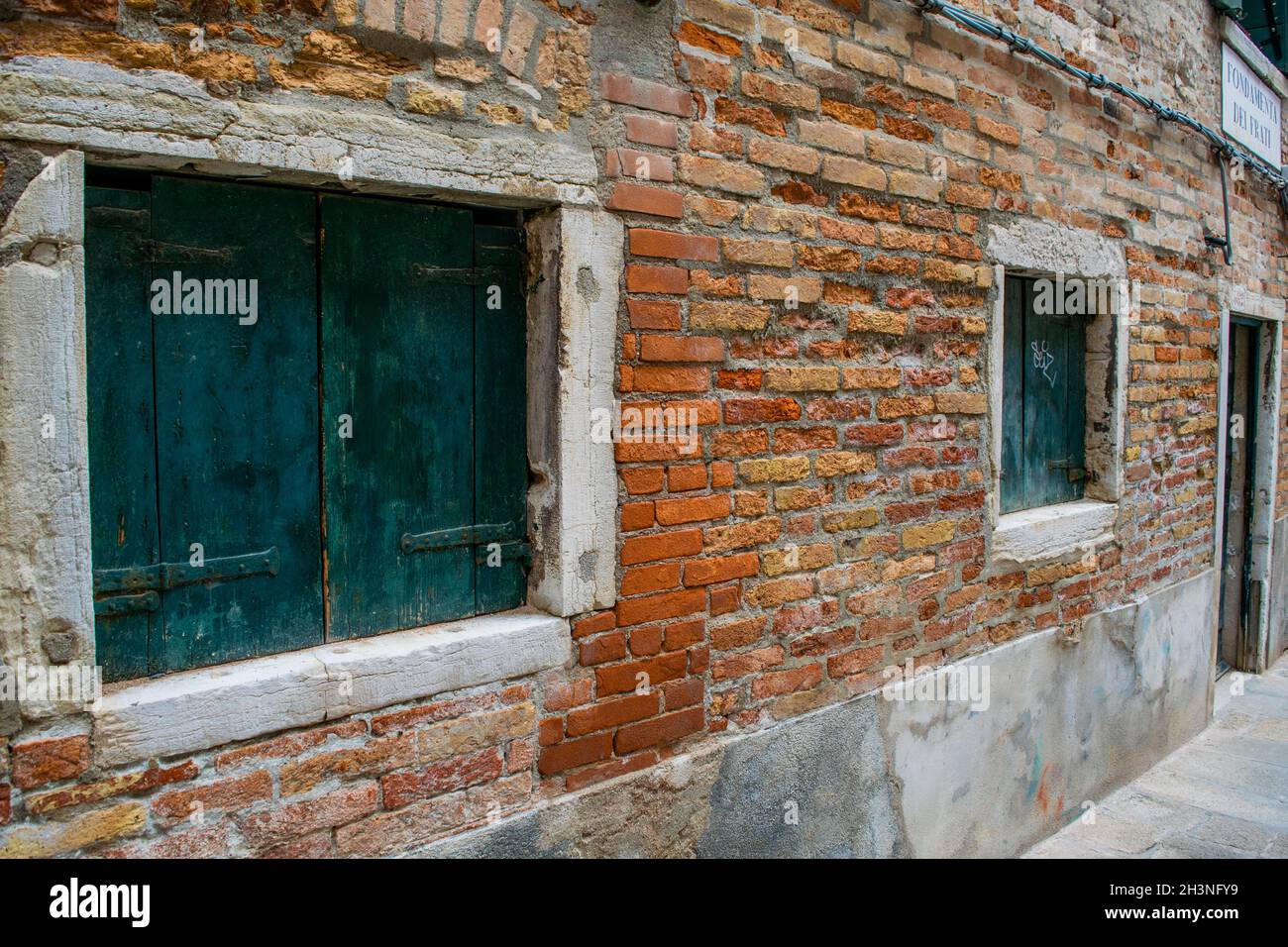 Old brick building facade with closed wooden windows Stock Photo - Alamy