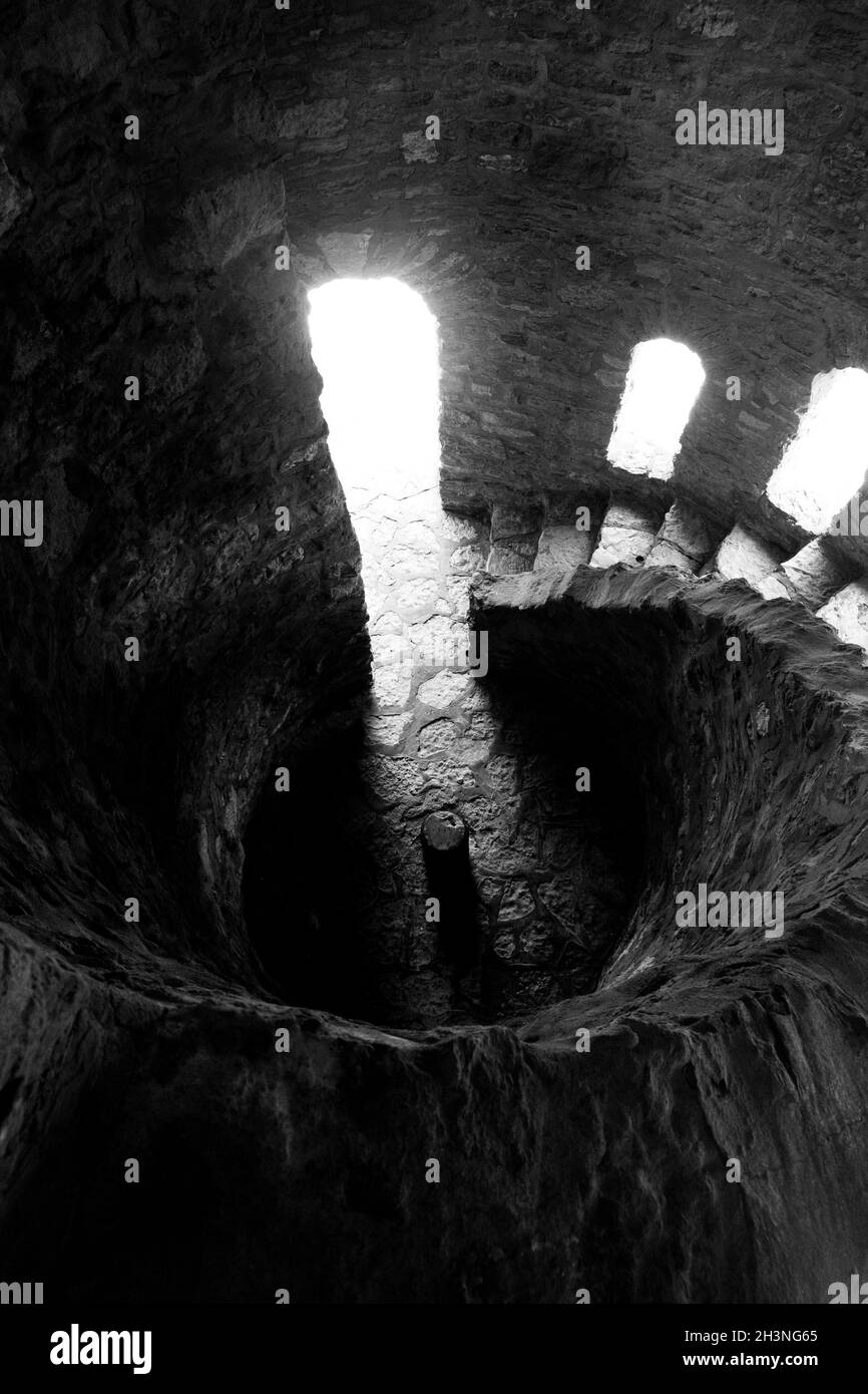Grayscale shot of a stone round staircase in a cave Stock Photo - Alamy