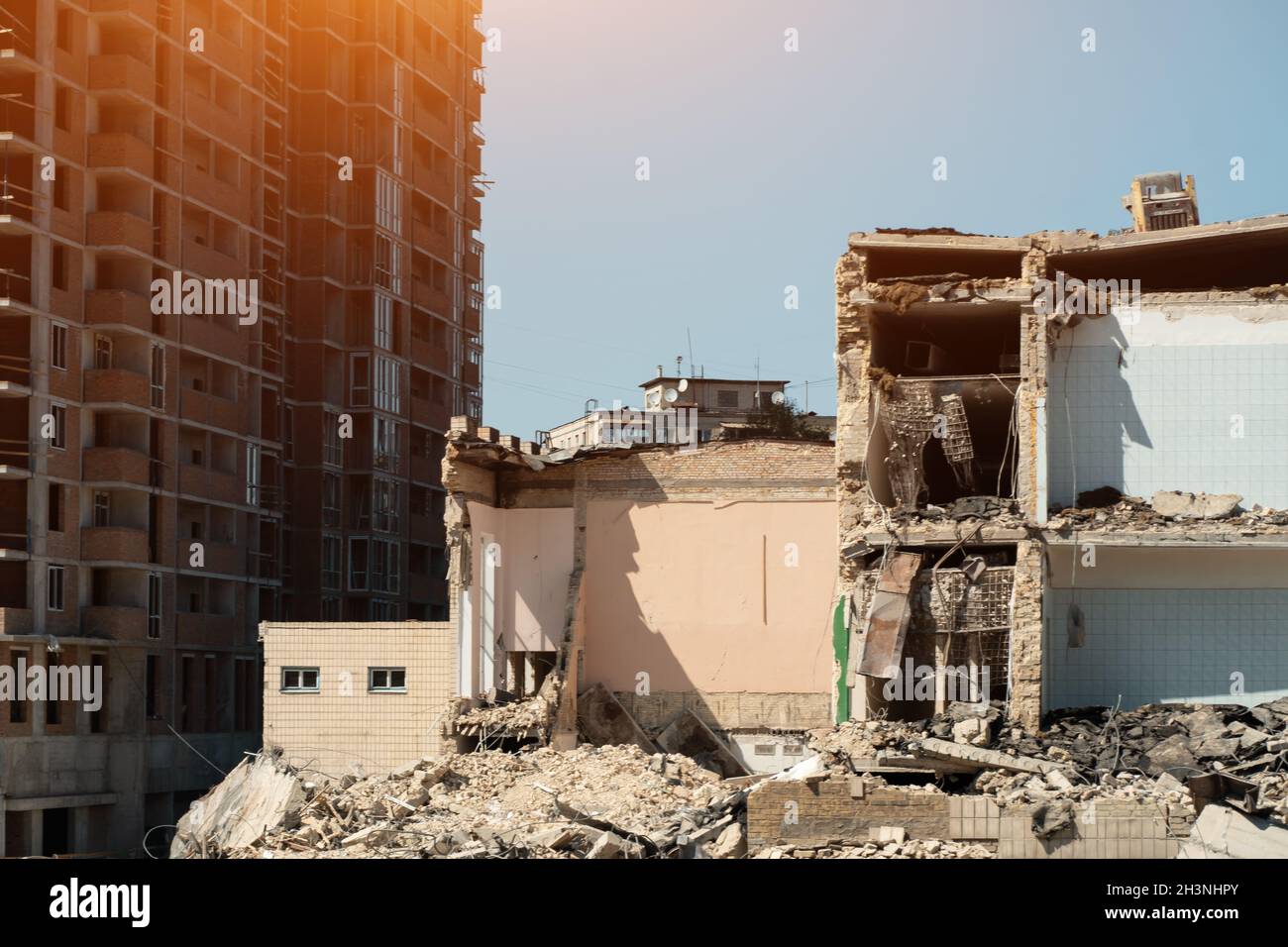 demolition of old building near new construction of modern skyscraper ...