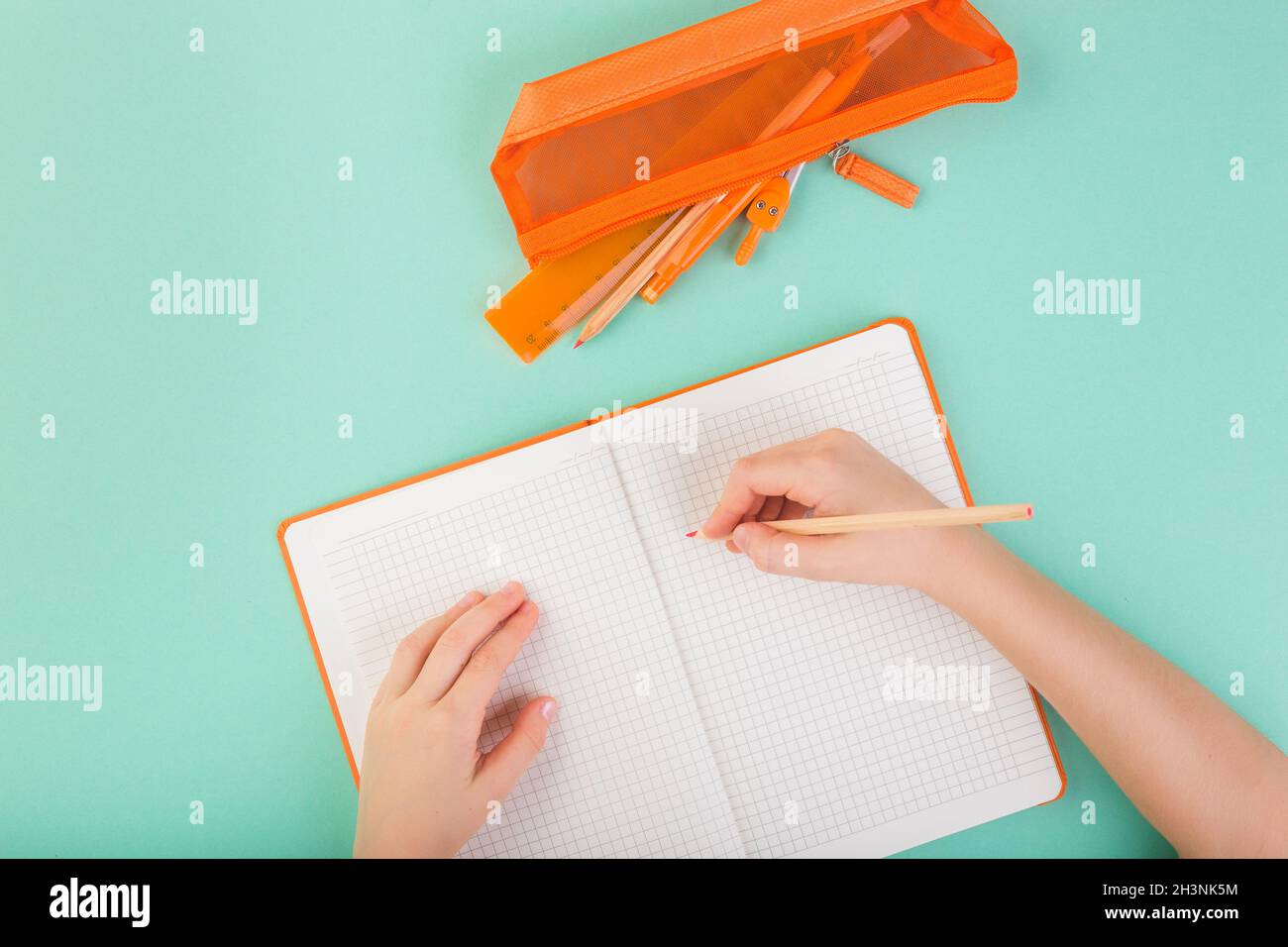 Top view of child hands writing in an empty notebook. Doing homework ...